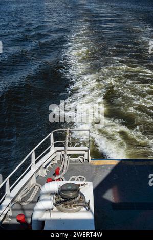 A big boat wake made by a ferry boat on Guanabara bay blue waters while ...