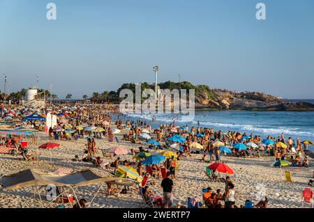 Heavily crowded Arpoador beach shoreline with Arpoador Rock (Pedra do ...