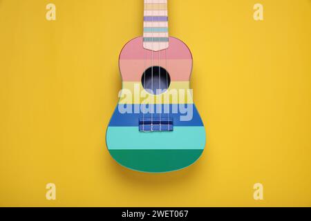 Colorful ukulele on yellow background, top view. String musical ...