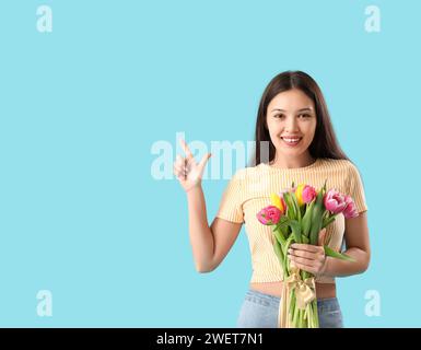 Beautiful women with flowers pointing at something on green background ...