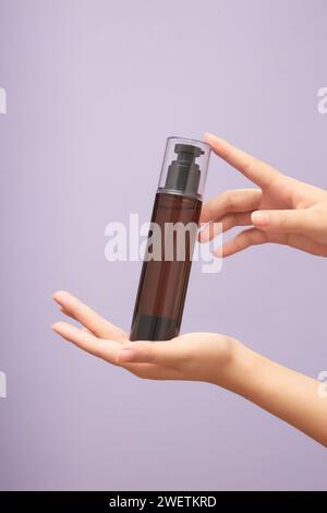 Unbranded brown plastic spray bottle on glass podium and brown herbs ...