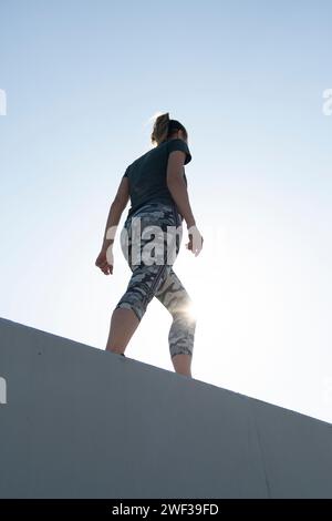 A back view of a fitness female walking on a street with a bag Stock ...