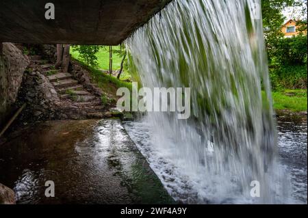 Passage under an artificial waterfall. Wall of water, falling cascade ...