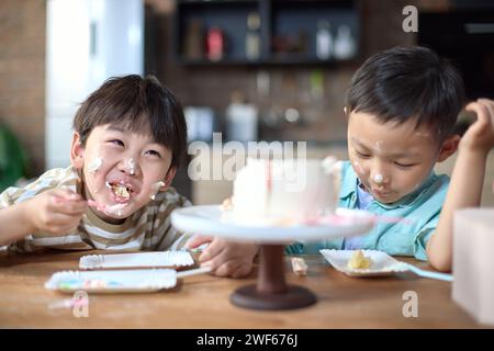 Two brothers eating birthday cake together Stock Photo - Alamy
