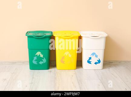 Containers for garbage near beige wall. Recycling concept Stock Photo ...