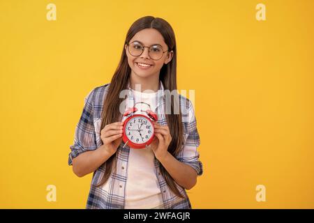 Teen girl organizing her schedule with a clock. Teen girl hold alarm ...