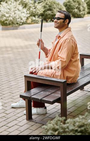 joyous indian blind man in blue tee shirt with glasses and walking ...