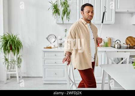 good looking indian disabled man in orange jacket with glasses and ...