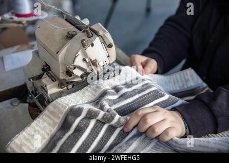 Overlocking the carpet edge in the carpet weaving factory. Factory ...