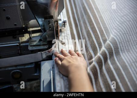 Overlocking the carpet edge in the carpet weaving factory. Factory ...