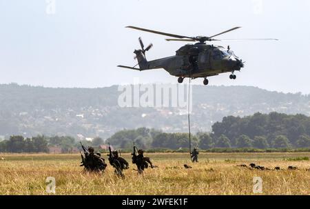 German army soldiers fast-roping from a NH90 helicopter and a Sikorsky ...