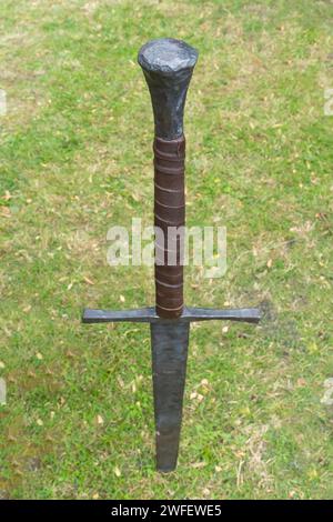 Sword stuck in the ground and metal knight helmet Stock Photo - Alamy