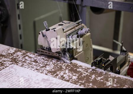 Overlocking the carpet edge in the carpet weaving factory. Factory ...