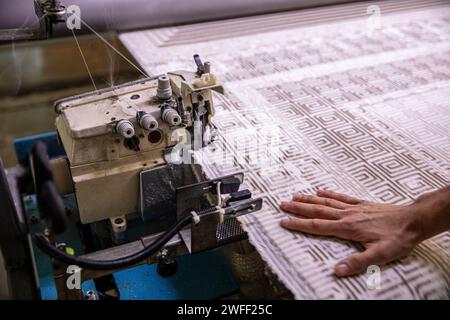 Overlocking the carpet edge in the carpet weaving factory. Factory ...