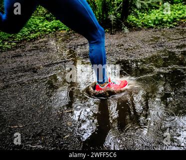 Female athlete running through puddle Stock Photo - Alamy