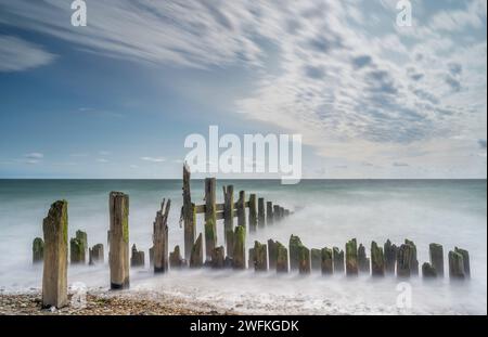 Old weathered groynes at Medmerry beach on the south coast with moody ...