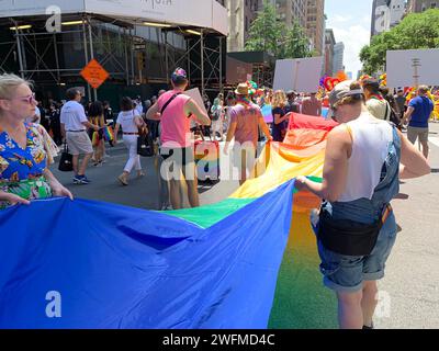 People carry a large pride flag as they march during the World Pride ...