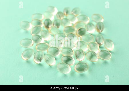 Many vitamin capsules on turquoise background, closeup Stock Photo - Alamy