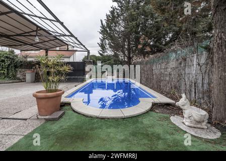 A swimming pool within a plot with a large awning covering the pool ...
