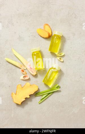 Glass jars of ginger tea with ingredients on wooden board over white ...