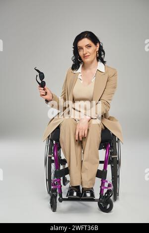 beautiful disabled woman in pastel suit in wheelchair putting on her ...