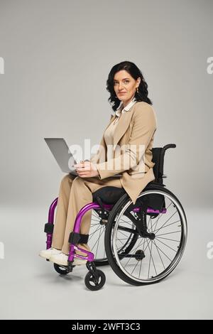 confident woman with disability in pastel elegant suit sitting in ...