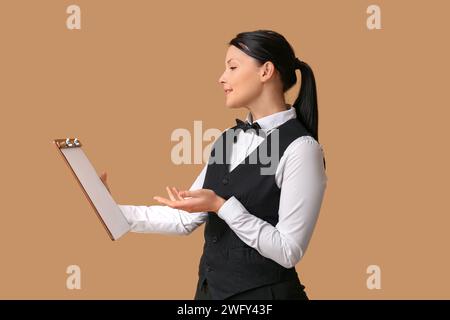 Beautiful young waitress with clipboard on green background Stock Photo ...