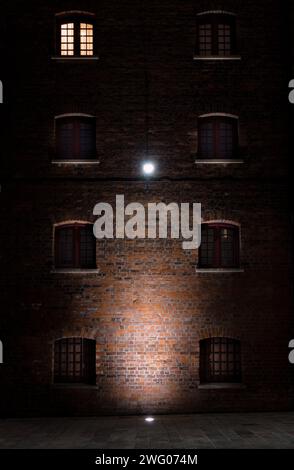 Illuminated Victorian brick warehouse windows at the historic docks at ...