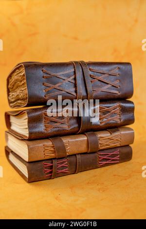 A stack of leather-bound journals, notebooks, cases, and wallets set on ...