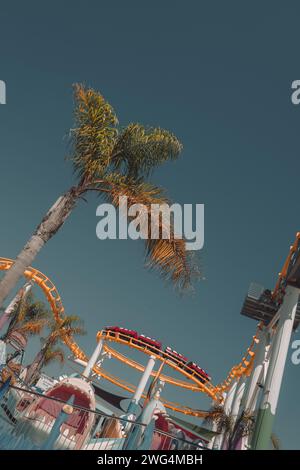 Moving roller coaster in an amusement park during the summer daytime ...
