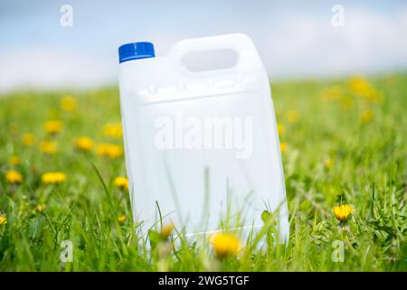 empty canister with herbicide and pesticides or fertilizers on a green ...