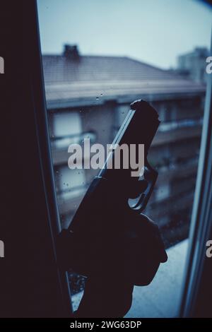Gunman holding pistole in window dramatic photo book cover design Stock ...