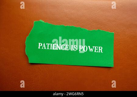 Patience is power lettering on ripped green paper with black background ...