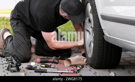 Driver Repairs Car Using Tools On Street Stock Photo - Alamy