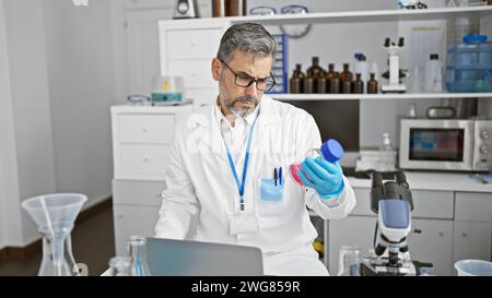 Young hispanic man scientist measuring liquid at laboratory Stock Photo ...
