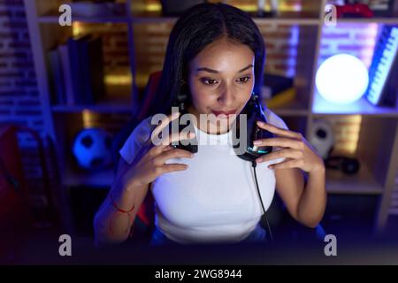 Young arab woman streamer sitting table with serious expression at ...