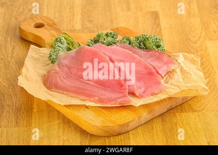 Raw salted tuna slice over board snack Stock Photo - Alamy