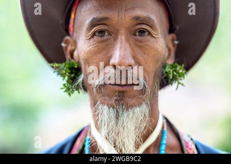 A Man from Wancho Naga tribe in his traditional clothes posing with a ...