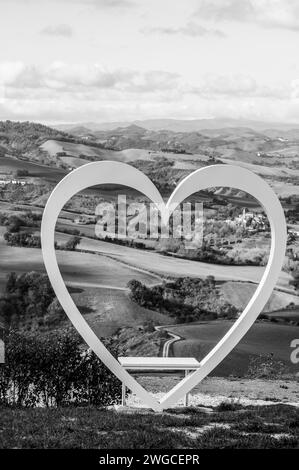 A heart shape sign at a scenic overlook with fields in the background ...