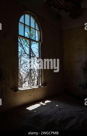An aged, dilapidated room with a big window in an old desert town Stock ...