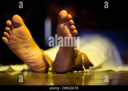 Feet of an Indian or Asian female dead body lying on floor in a dark ...
