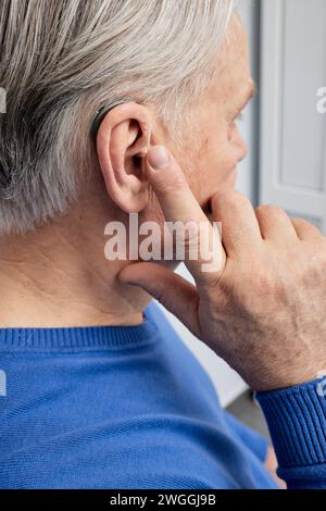 Senior man can hear sounds with hearing aid behind the ear with virtual ...