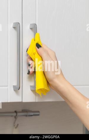 woman's hand wipes a kitchen cabinet with a rag. woman wiping the ...