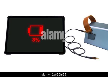 Tablet PC next to a power bank (charging station) with a USB cable on a ...