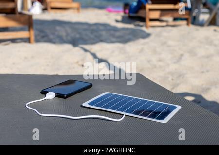 solar charger charging smartphone on beach Stock Photo - Alamy