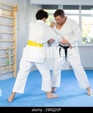 Individual judo lesson for teenager - guy and trainer are sparring in ...