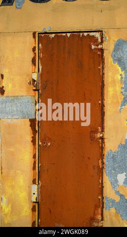Large brightly painted yellow door on a lock-up in an industrial ...