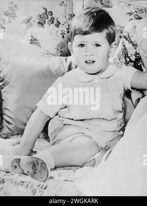 Photograph of a young Charles III seated on the lap of his mother ...