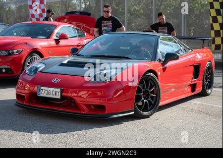 Front view of a stunning mid-engine V6 Honda NSX. It is red with black ...