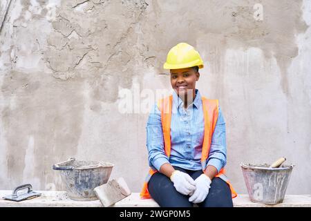 Smiling female bricklayer amidst buckets Stock Photo - Alamy